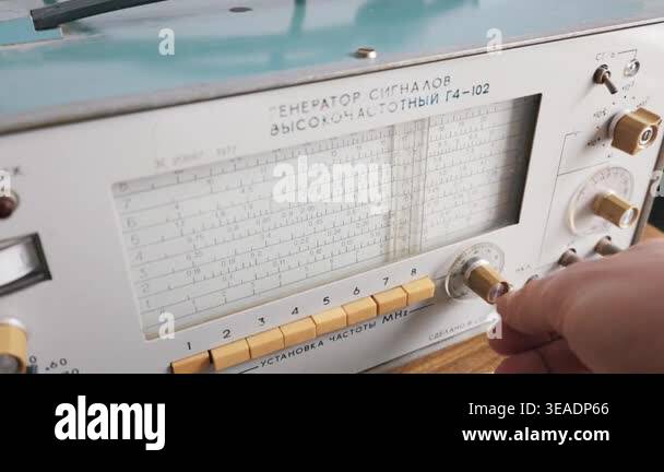 A close-up of a hand turning the knob on a vintage Soviet-era high ...