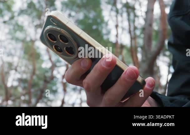 A person holds a green smartphone with a prominent circular camera ...