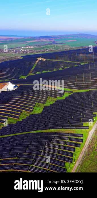 Multiple sections of solar panel arrays integrated into the green hilly ...