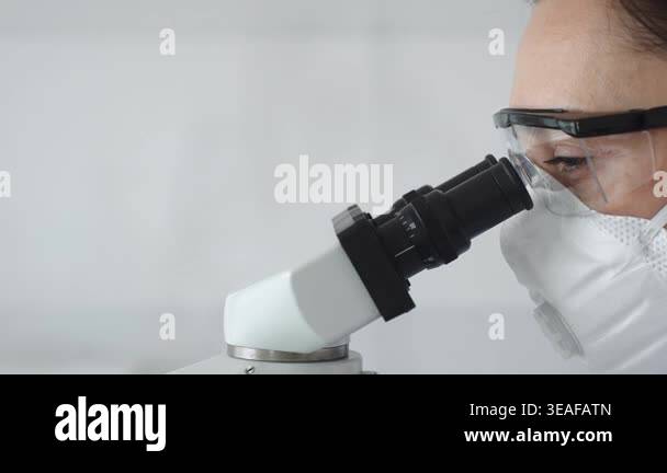 Close up of woman scientist wearing protective mask and goggles ...