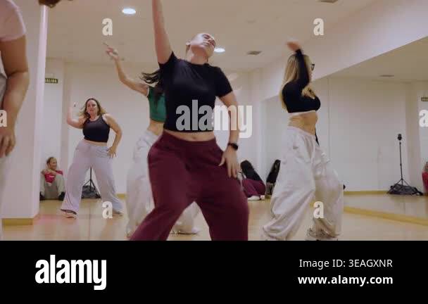 Group of energetic young women learning and rehearsing a modern hip-hop ...