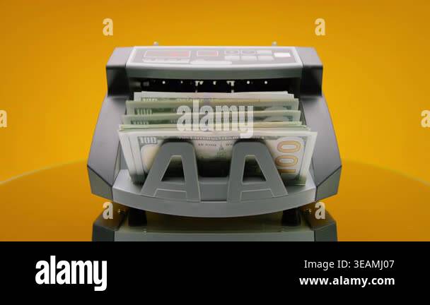 Close-up of a cash counting machine filled with US hundred dollar bills ...