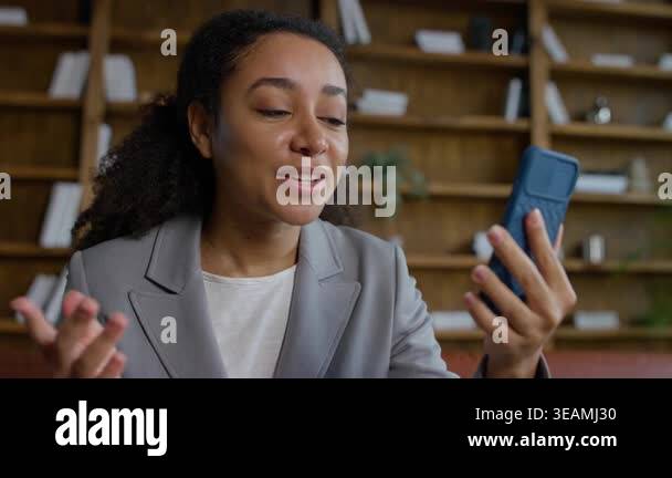 Professional businesswoman talks on her smartphone in a home office ...