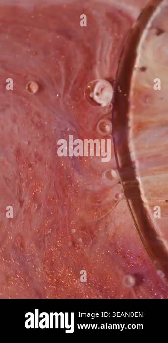 Vertical video. Oil fluid. Color bubbles. Defocused orange purple ...