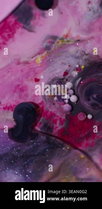Vertical video. Spill bubbles. Oil blend. Defocused purple red pink ...