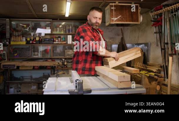 Joinery process. Stacking wood. Bearded carpenter placing freshly cut ...