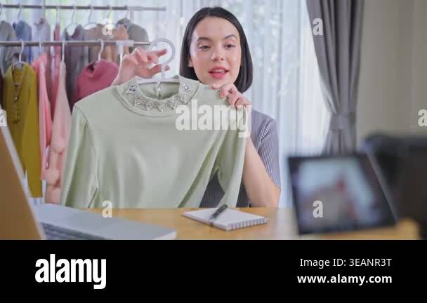 Young woman showcasing a green sweater while sitting at a desk in a ...