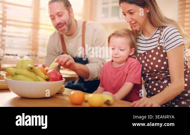Caucasian parents teaching and motivate young baby eat healthy fruit ...