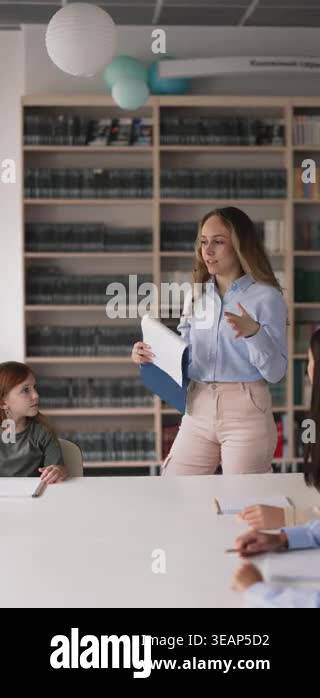 Female teacher interacts with school children, asking question, high ...
