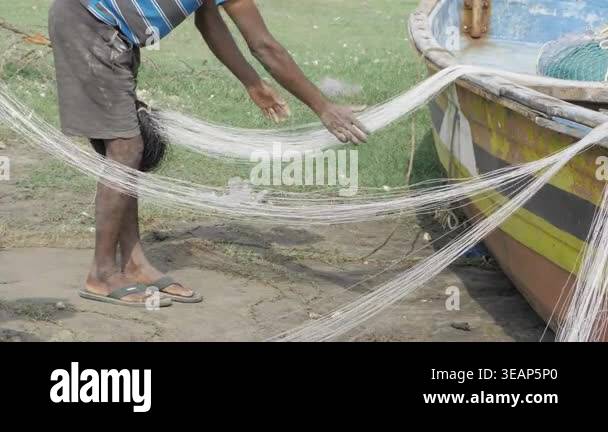 Person using fishing net to catch fish near a water source in a natural ...