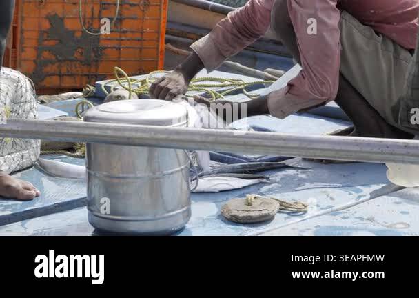 Person preparing catch of the day on a boat deck with fishing gear and ...