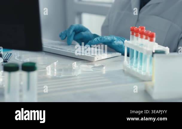 Laboratory professional types on a keyboard while conducting research ...