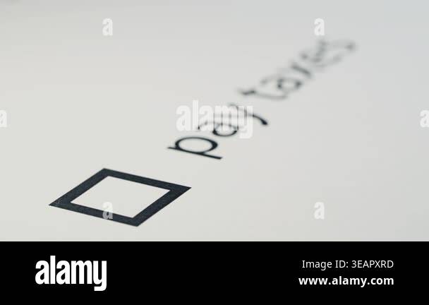 Close-up of woman marking Pay Taxes checkbox on white paper form ...