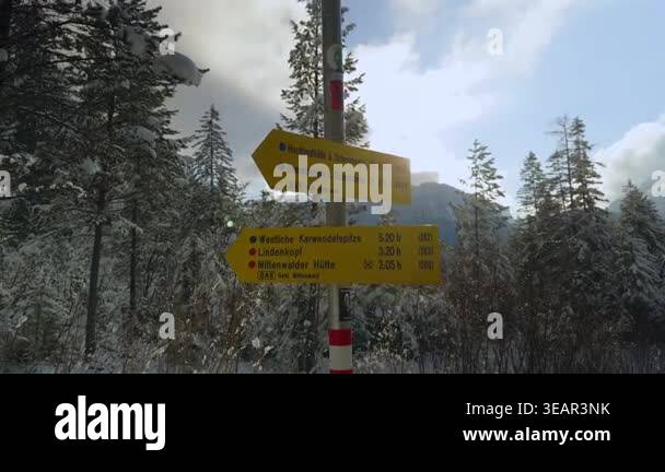Yellow hiking trail signpost in snowy forest near Mittenwald, Bavaria ...