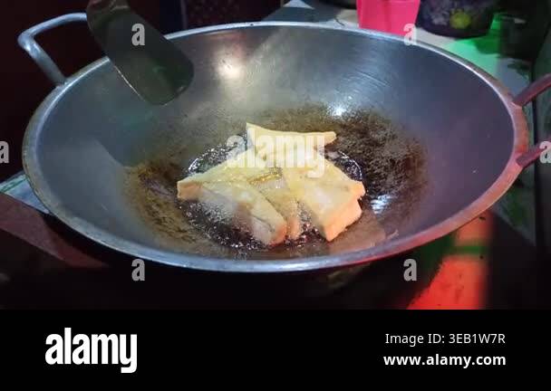 Fresh tofu is being fried in preparation for tahu tek street food ...