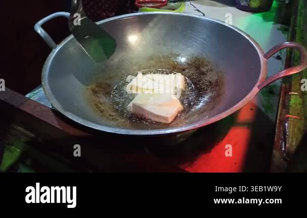 Fresh tofu is being fried in preparation for tahu tek street food ...