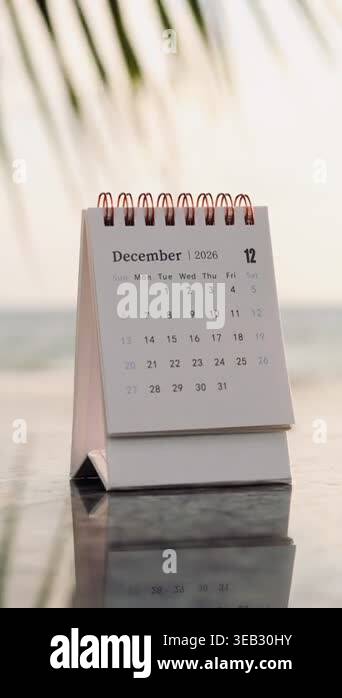 A close-up of a hand flipping a calendar page from December 2026 to ...