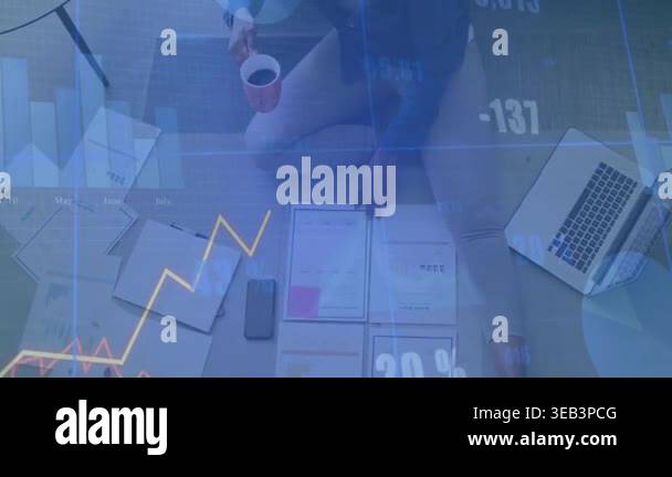 Mid woman kneeling on rug reviewing financial charts and sipping coffee ...
