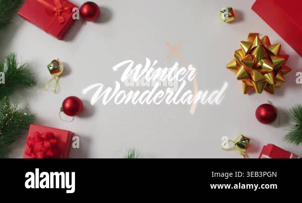 Animation of winter wonderland text over christmas decorations on white ...