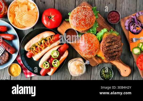 Summer BBQ food table scene with hot dog and hamburger buffet. Slow ...