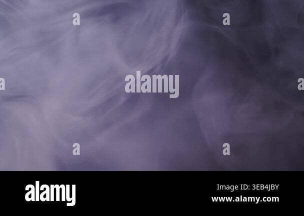 Soft purple smoke drifts and swirls slowly across a dark background ...