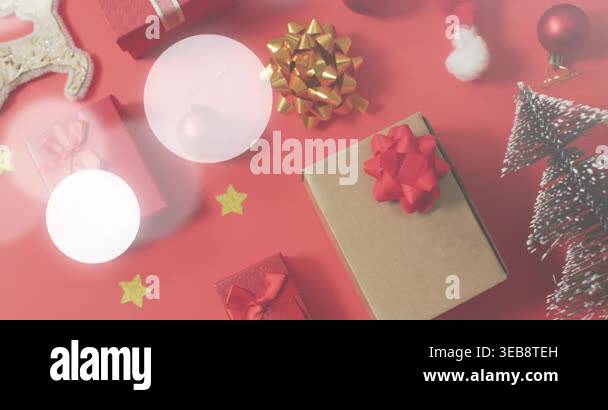 Soft light rings drifting onto flat red decor overlapping gift boxes ...