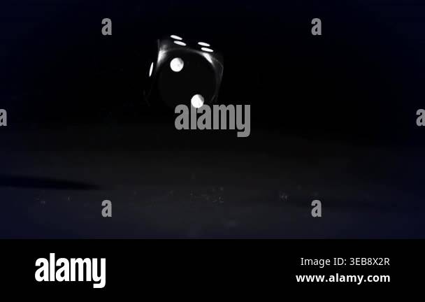 After initial toss glossy black die tumbling and rotating above mirror ...
