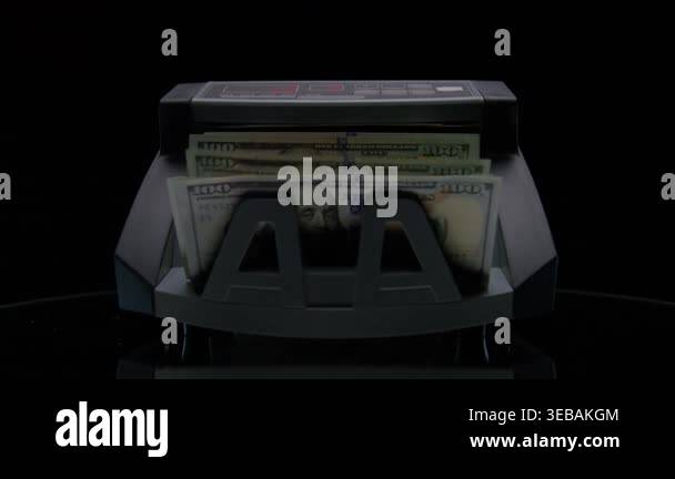 Front-facing view of a money counting machine processing US hundred ...