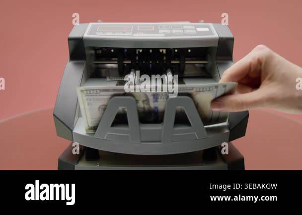 Close-up of a cash counting machine processing a hundred dollar bill ...