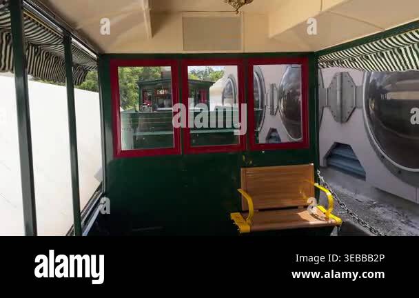An empty vintage train car interior features wooden seating and green ...