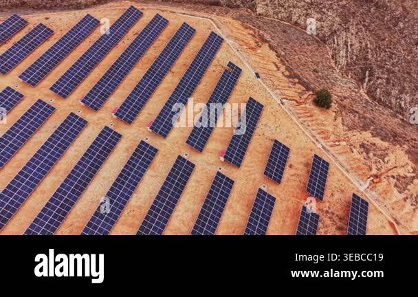 Rows of solar panels are arranged in a rural area of Spain. The sun ...