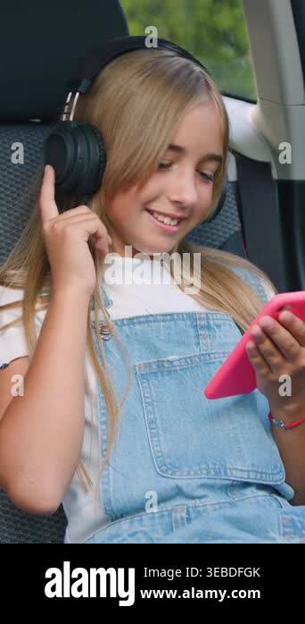 Pretty teenage girl 10-year-old girl sitting backseat in car and using ...