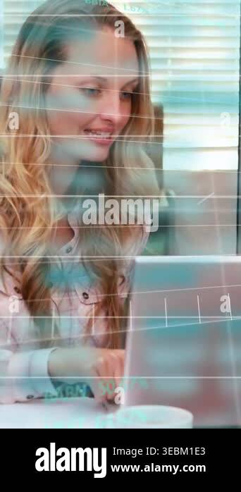 Vertical video: Woman typing at laptop, noting, causing finance charts ...