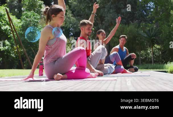 People practicing yoga outdoors with digital globe animations floating ...