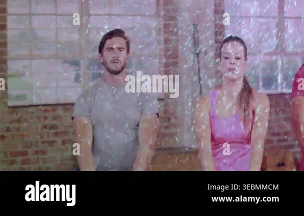 Three exercisers swinging kettlebells in warehouse gym, breath ...