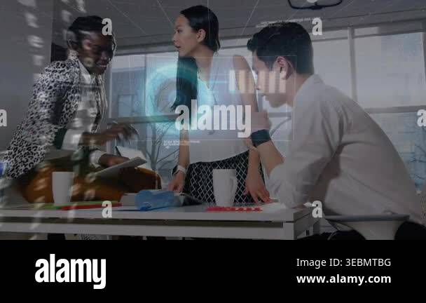 3 colleagues gathering around low table, pointing at tablet, initiating ...