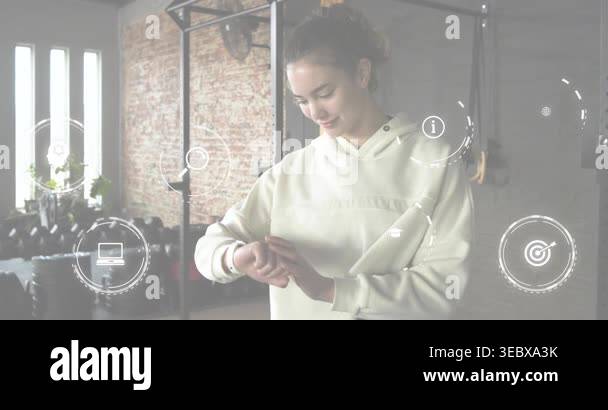Female gym-goer looking down, tapping smartwatch in gym, generating HUD ...