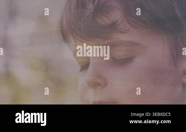 Boy holding eyes closed, outdoor close-up showing eyelid and lip ...