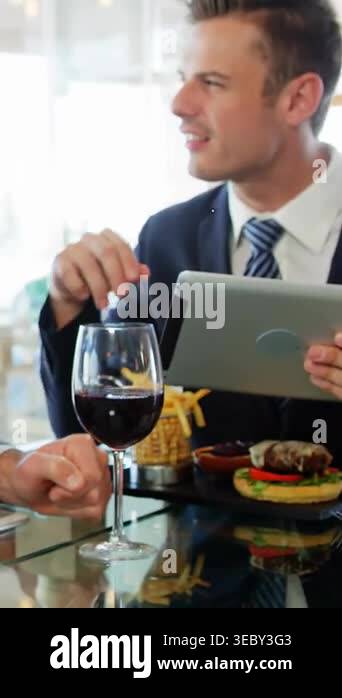 Vertical video: Man using tablet at business lunch moving network nodes ...