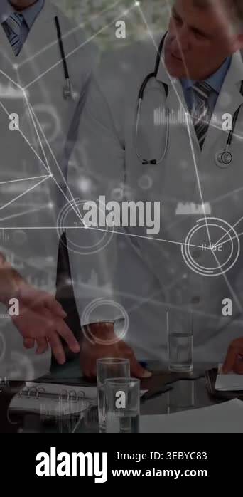 Vertical video: Two health docs leaning over table, pointing at files ...