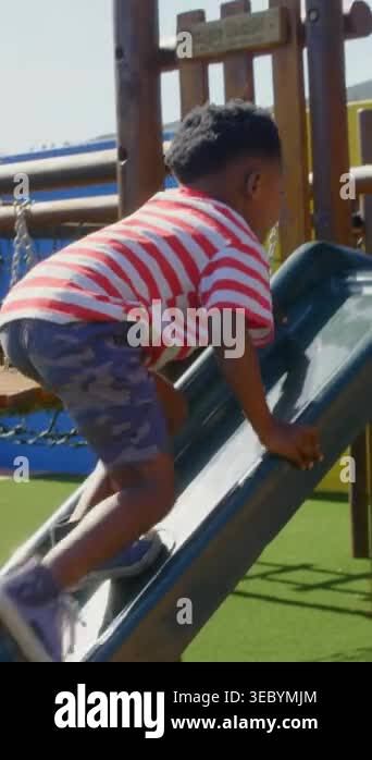 Vertical video: Boy climbing plastic ramp pulling and reaching wanting ...
