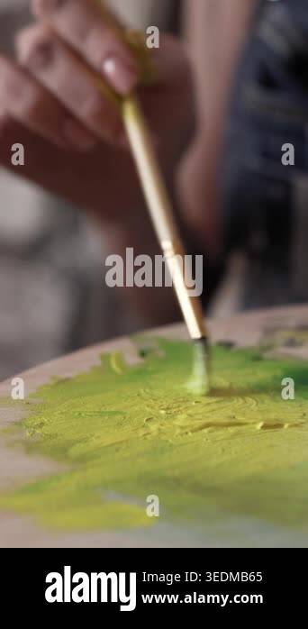 Close-up of painter mixes watercolor paints on palette to create ...