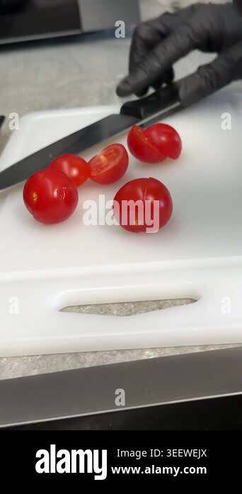 ifting knife, chopping tomatoes in kitchen, wearing black latex gloves ...