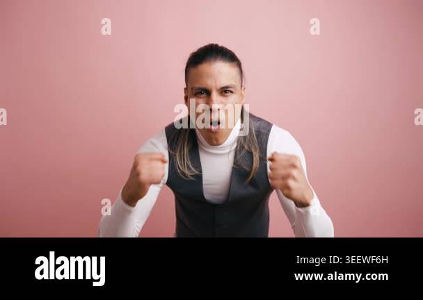 Cheerful hispanic man with long hair clenching his fists and ...