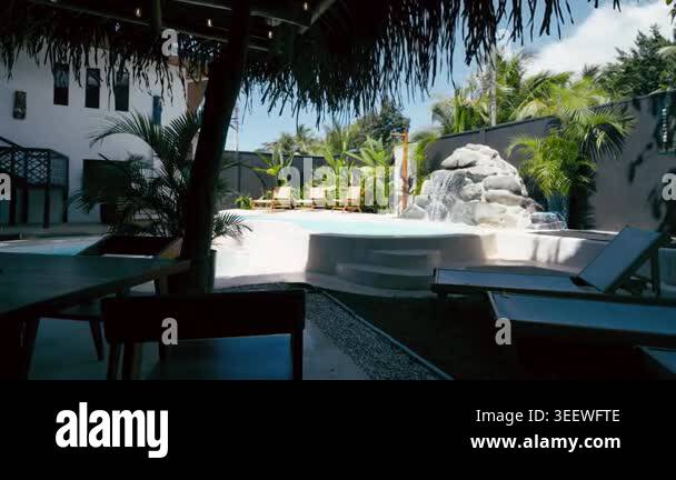 Empty poolside at a tropical luxury hotel with a swimming pool, rock ...