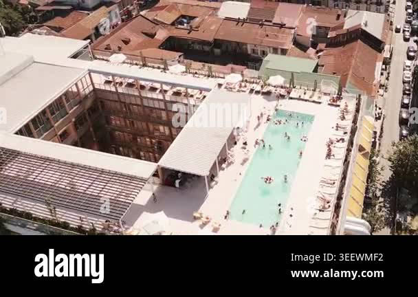 Aerial tilt up view Batumi Georgia rooftop swimming pool with people ...