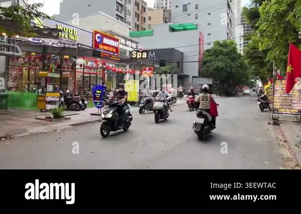 Real everyday street scene near the coastline. Locals walk, ride ...