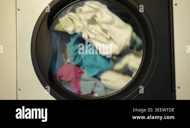 View inside a front-loading laundry machine where blue pink white and ...