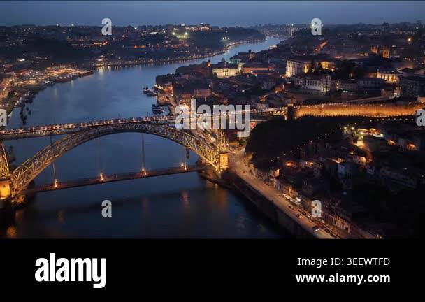 An aerial panorama captures Porto Portugal at night. The iconic Dom ...