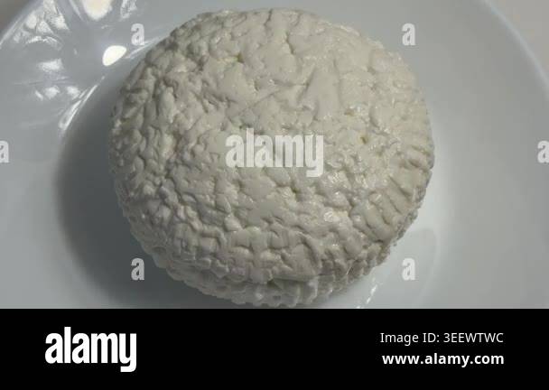 Fresh farm-style cheese on a white plate, a natural dairy product ...